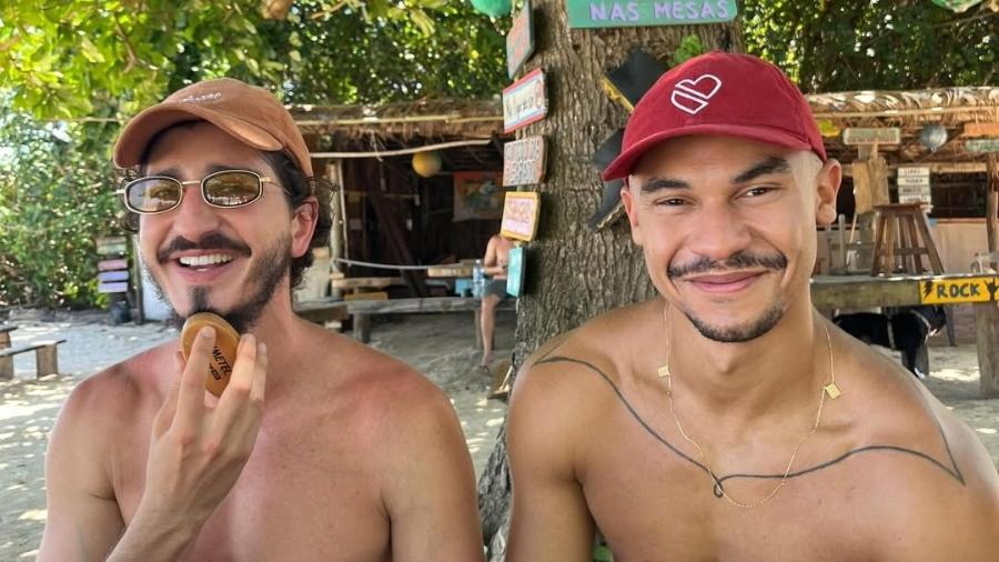 Johnny Massaro posa com atual namorado na praia da Bahia